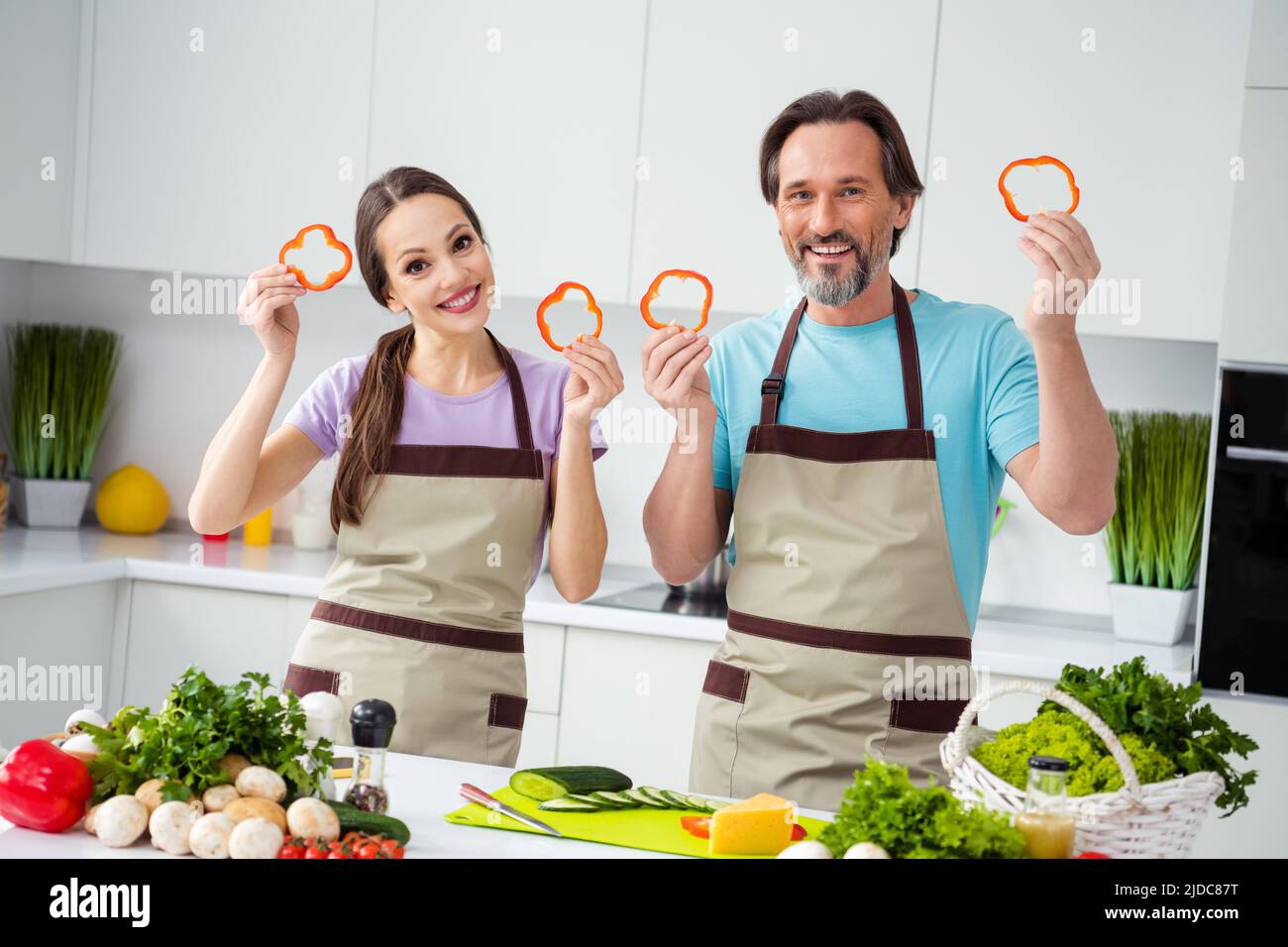 Photo of two cheerful friendly people hold paprika pepper fresh slices ...