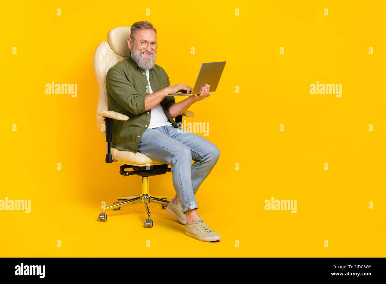 Full length portrait of cheerful aged man sitting chair hold use ...