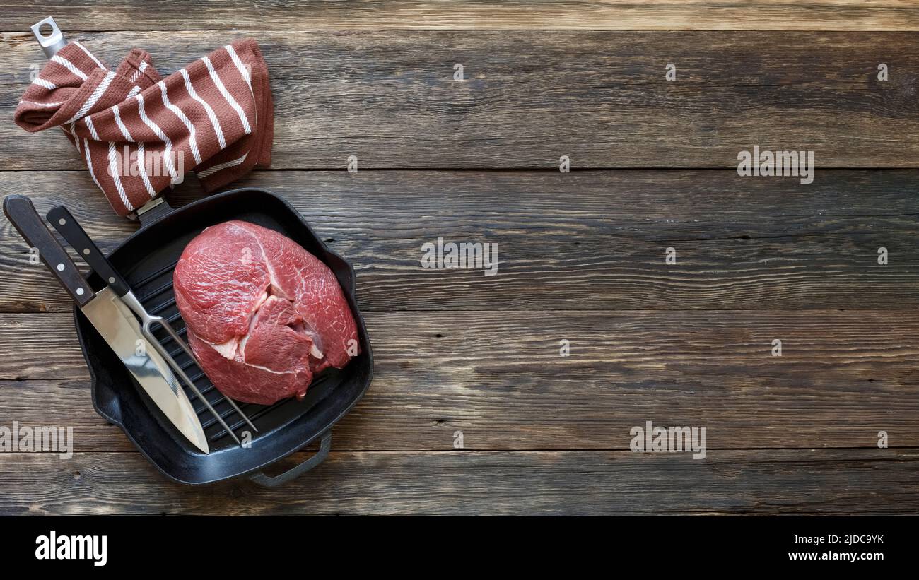 Raw piece of meat for grilling with vegetables in a cast iron pan ...