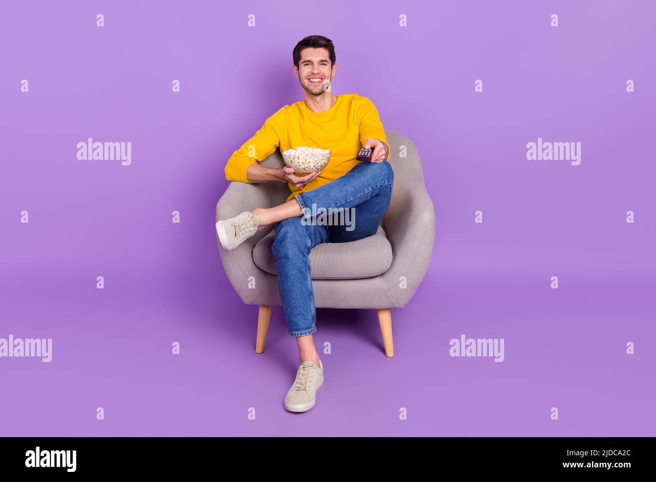 Full length image of good mood positive man sit chair watching tv after ...