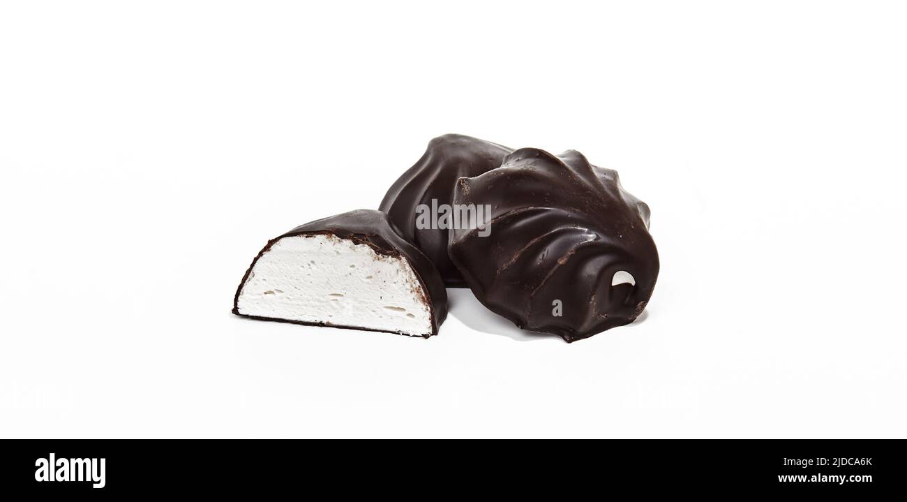 Close-up shot of whole marshmallows and one half covered with chocolate ...