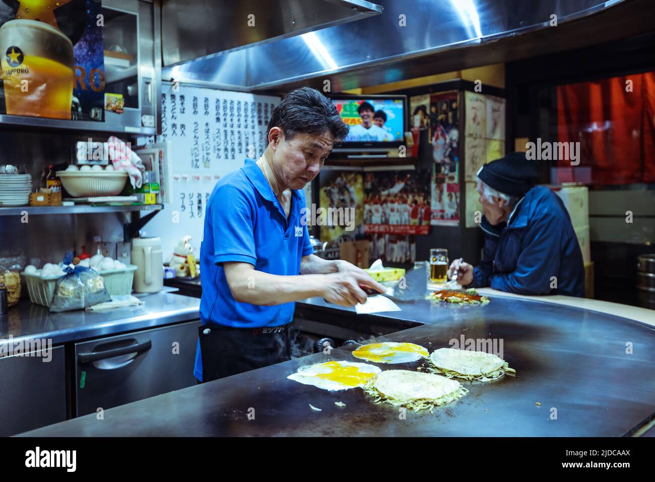 Local Cook preparing the Typical Japanese Dish Okonomiyaki in Hiroshima ...