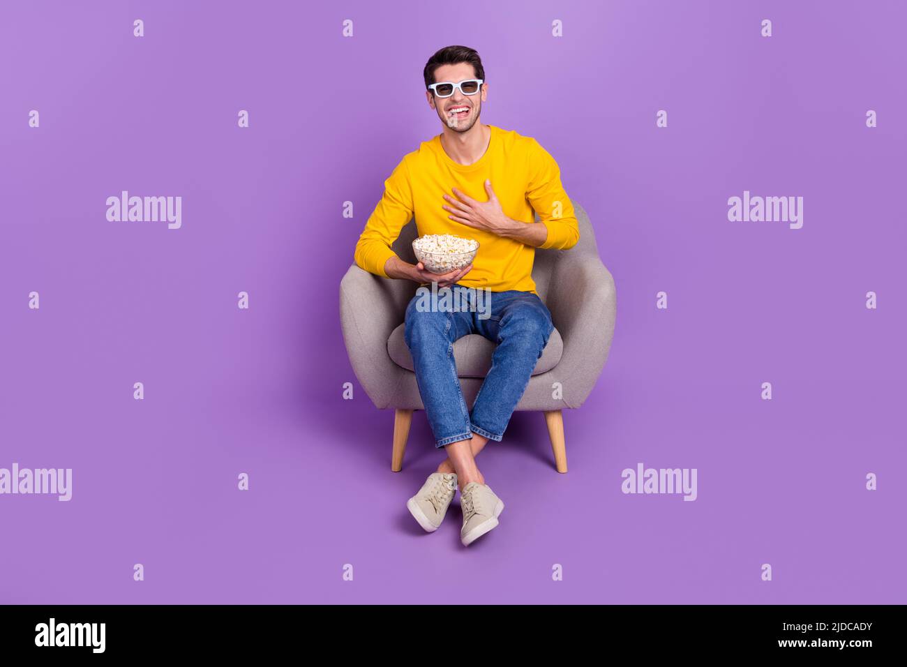 Photo of cheerful excited smiling man sit cozy armchair watching good ...