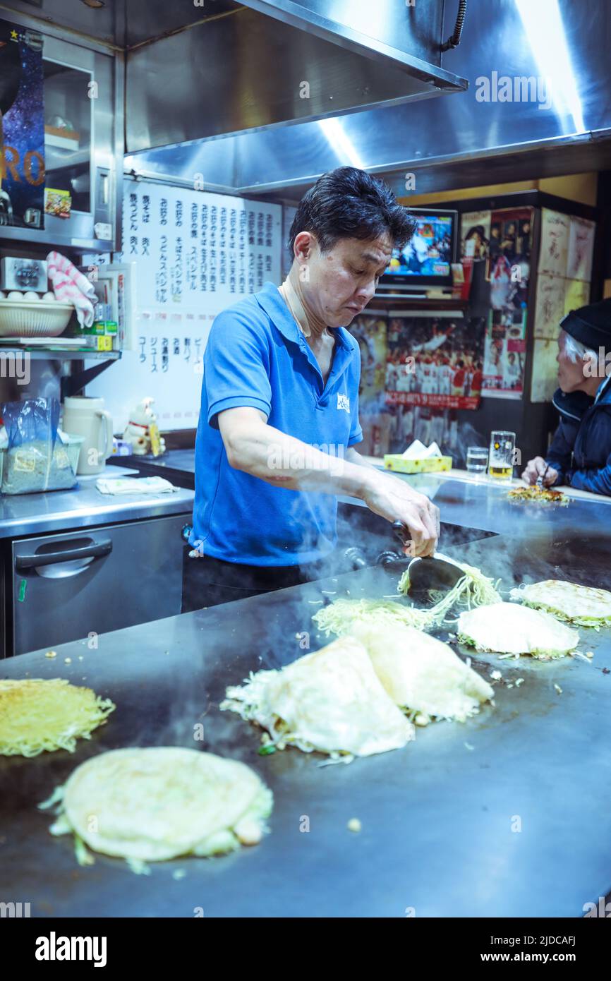 Local Cook preparing the Typical Japanese Dish Okonomiyaki in Hiroshima ...