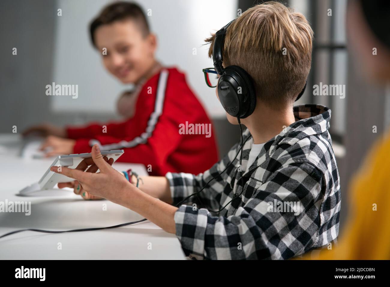 Schoolboy using computer in classroom at school Stock Photo - Alamy