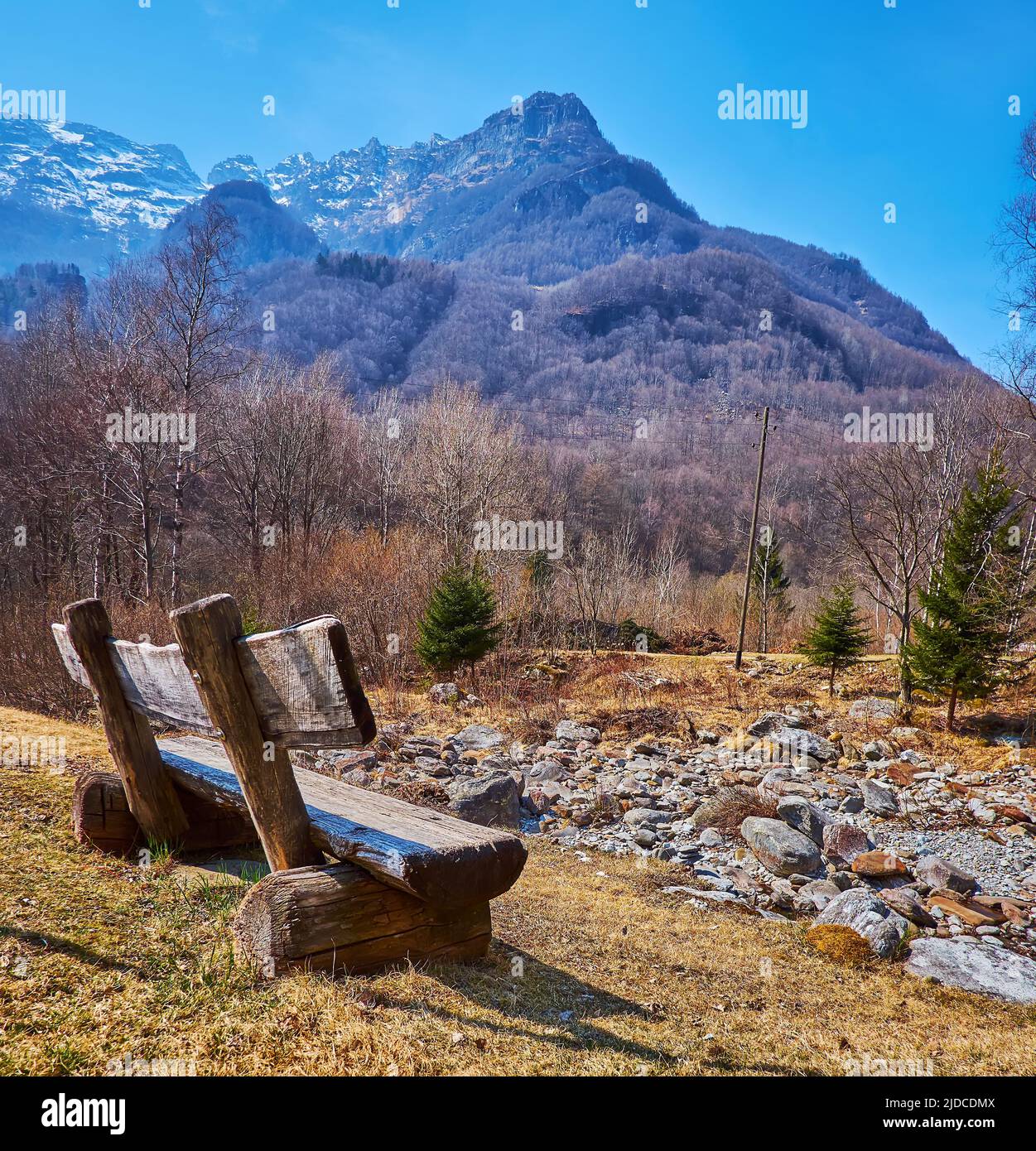 The old timber bench at the shallow Riale Efra River with a view of ...