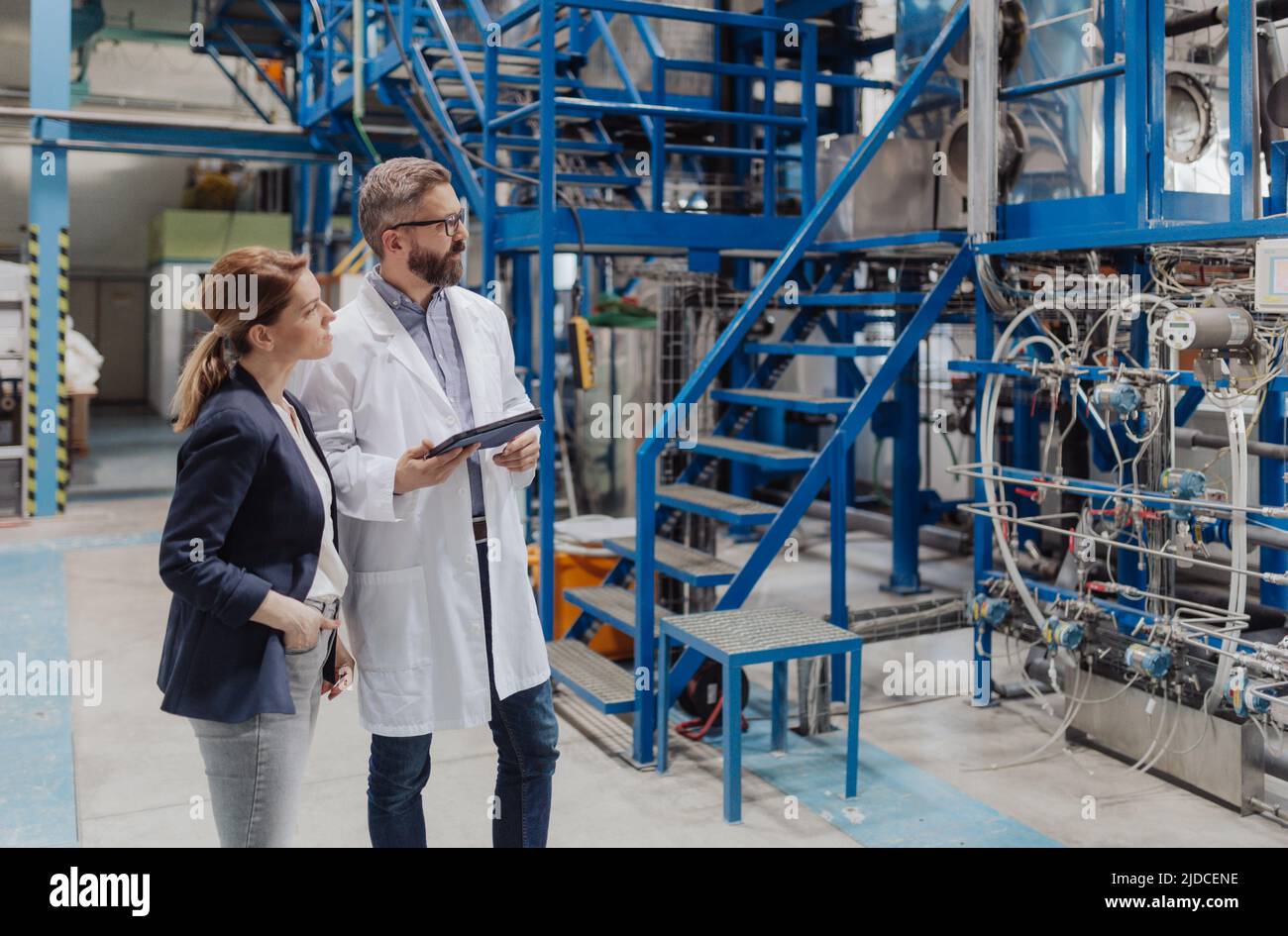Engineering managers with tablet doing routine check up in industrial ...