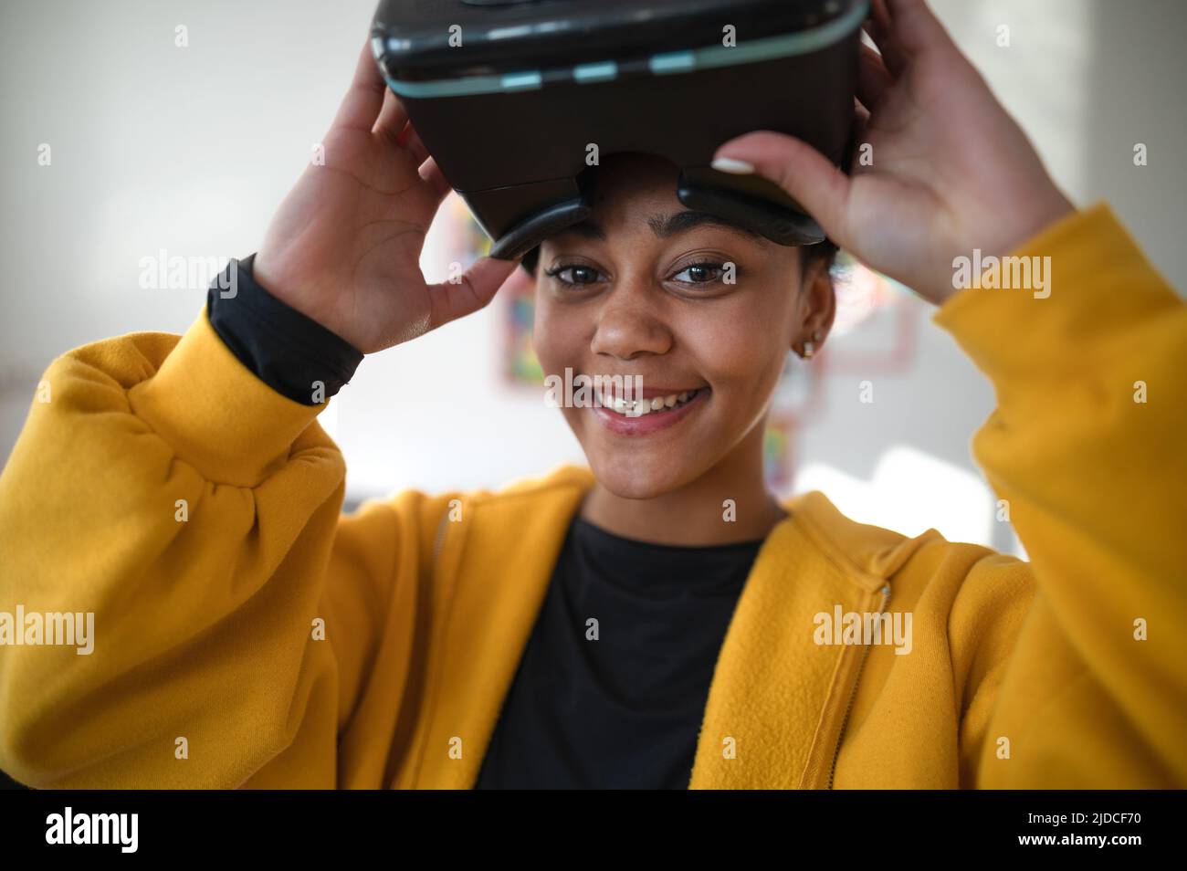 Happy student wearing virtual reality goggles at school in computer ...