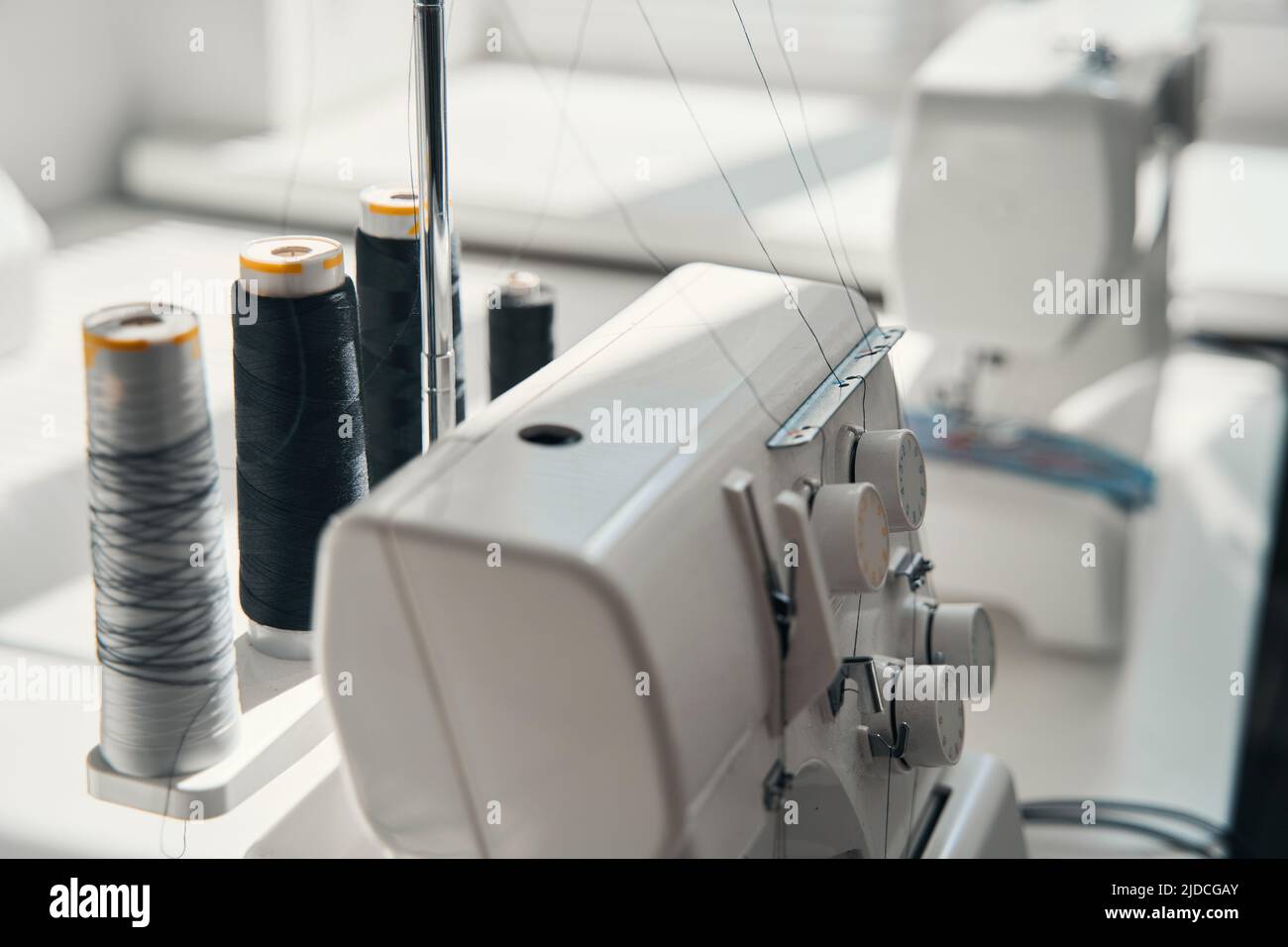 Sewing machine and thread on tailor desk Stock Photo - Alamy