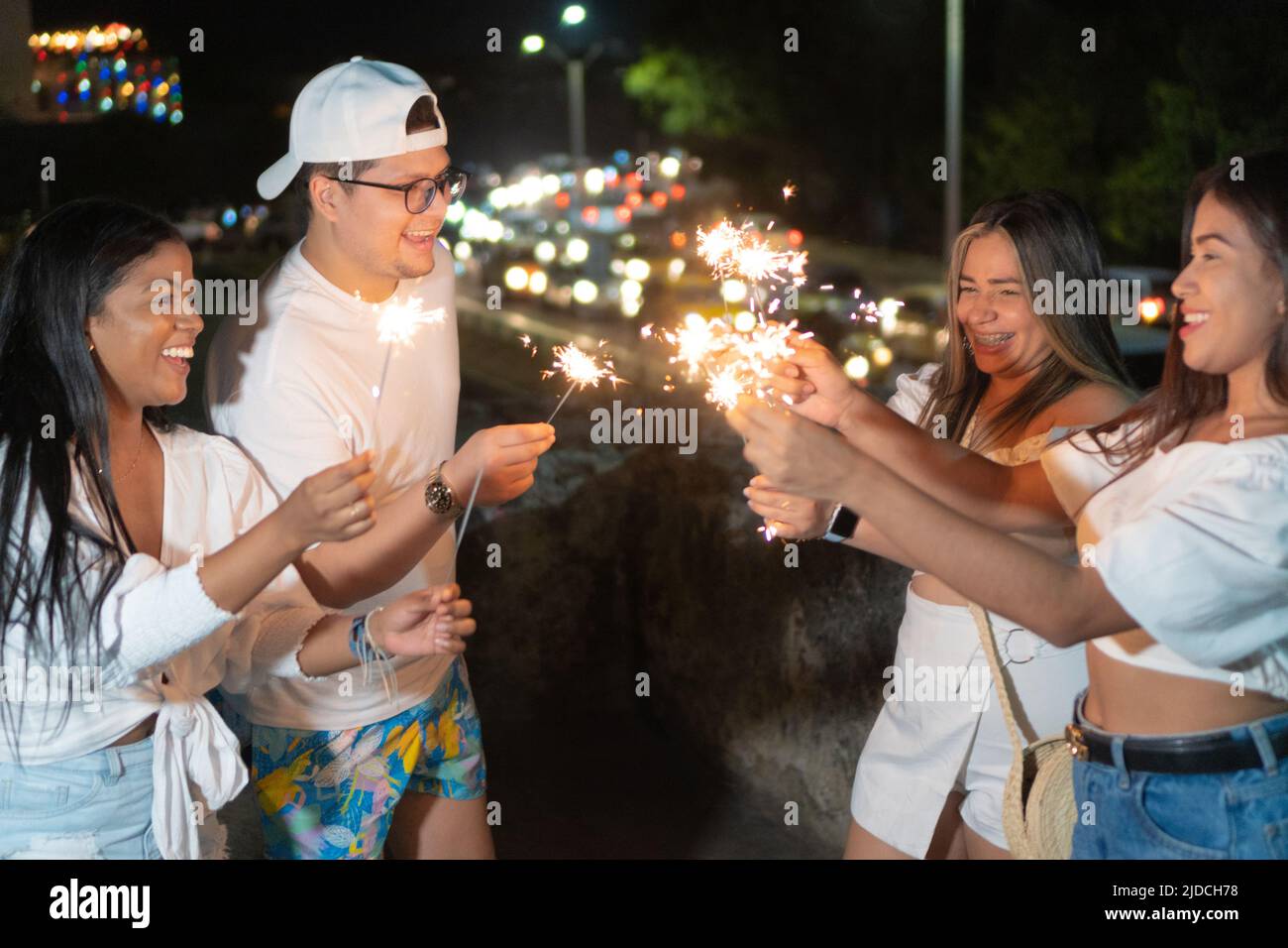 Four friends with sparklers at outdoor party Stock Photo - Alamy