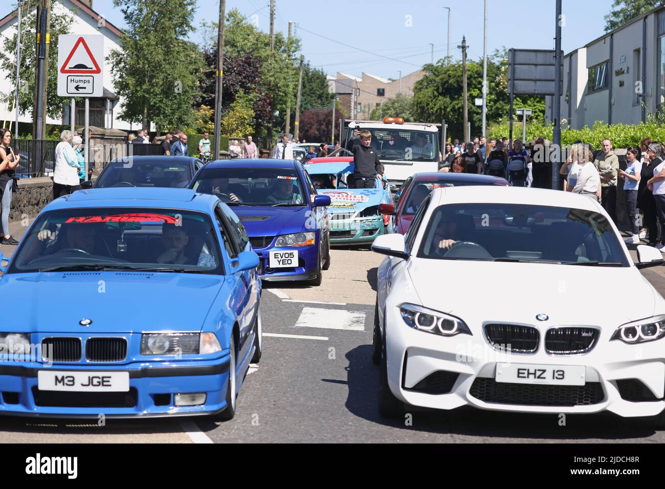 Sports cars lead the funeral procession towards All Saints Church in ...