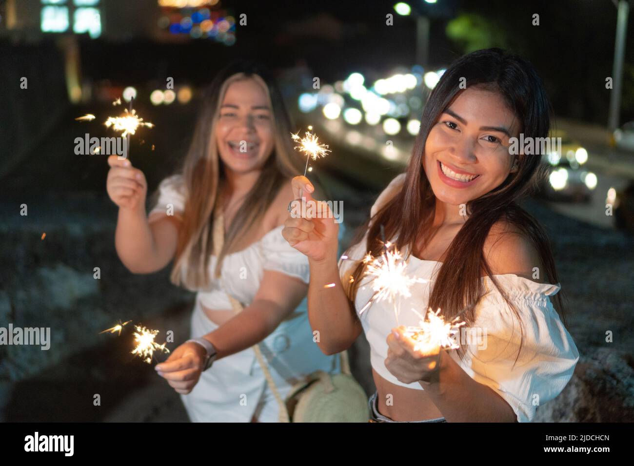 Young people laughing and burning flares during a nighttime party Stock ...