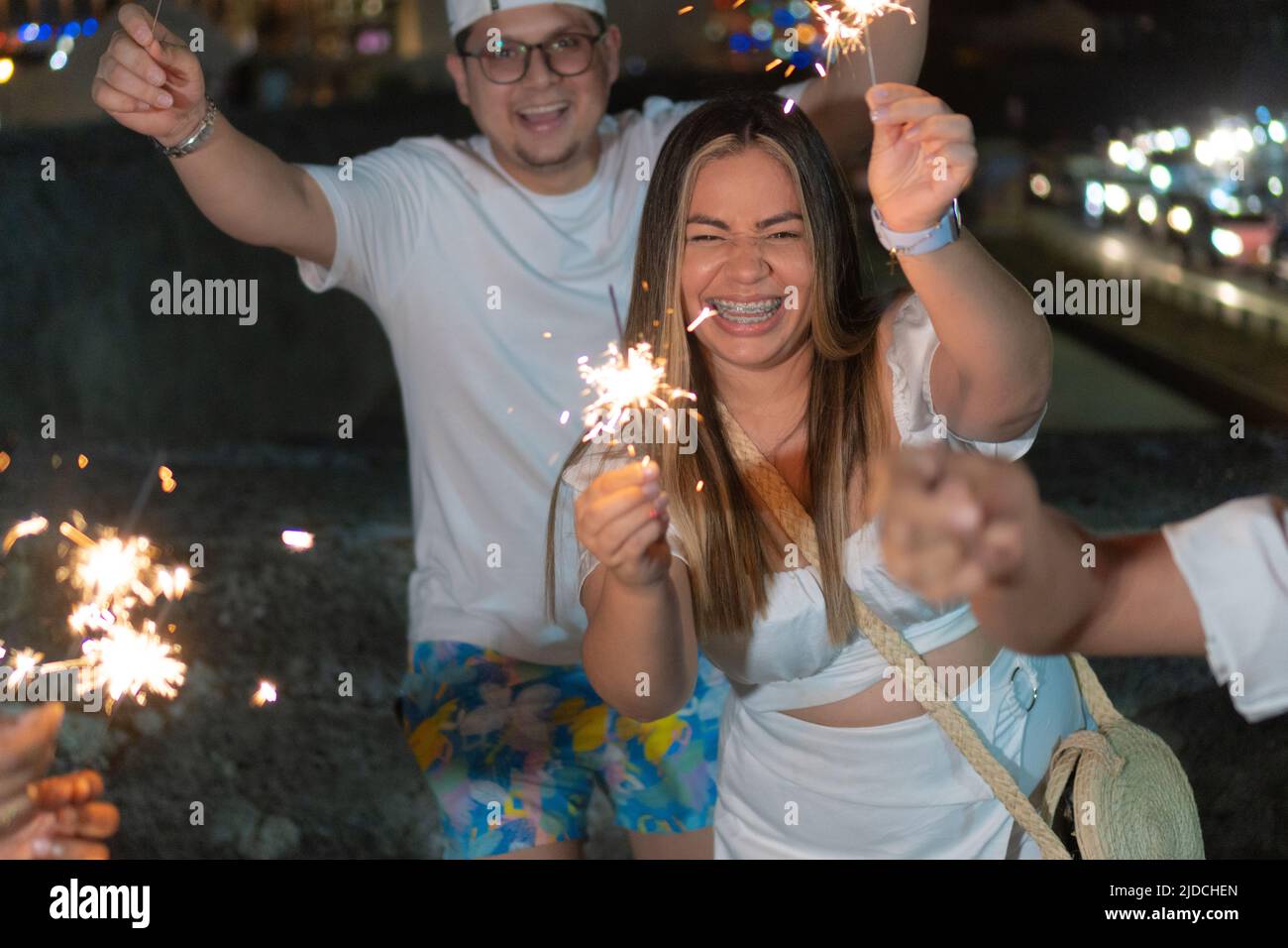 Group of friends laughing and burning flares during a night party Stock ...