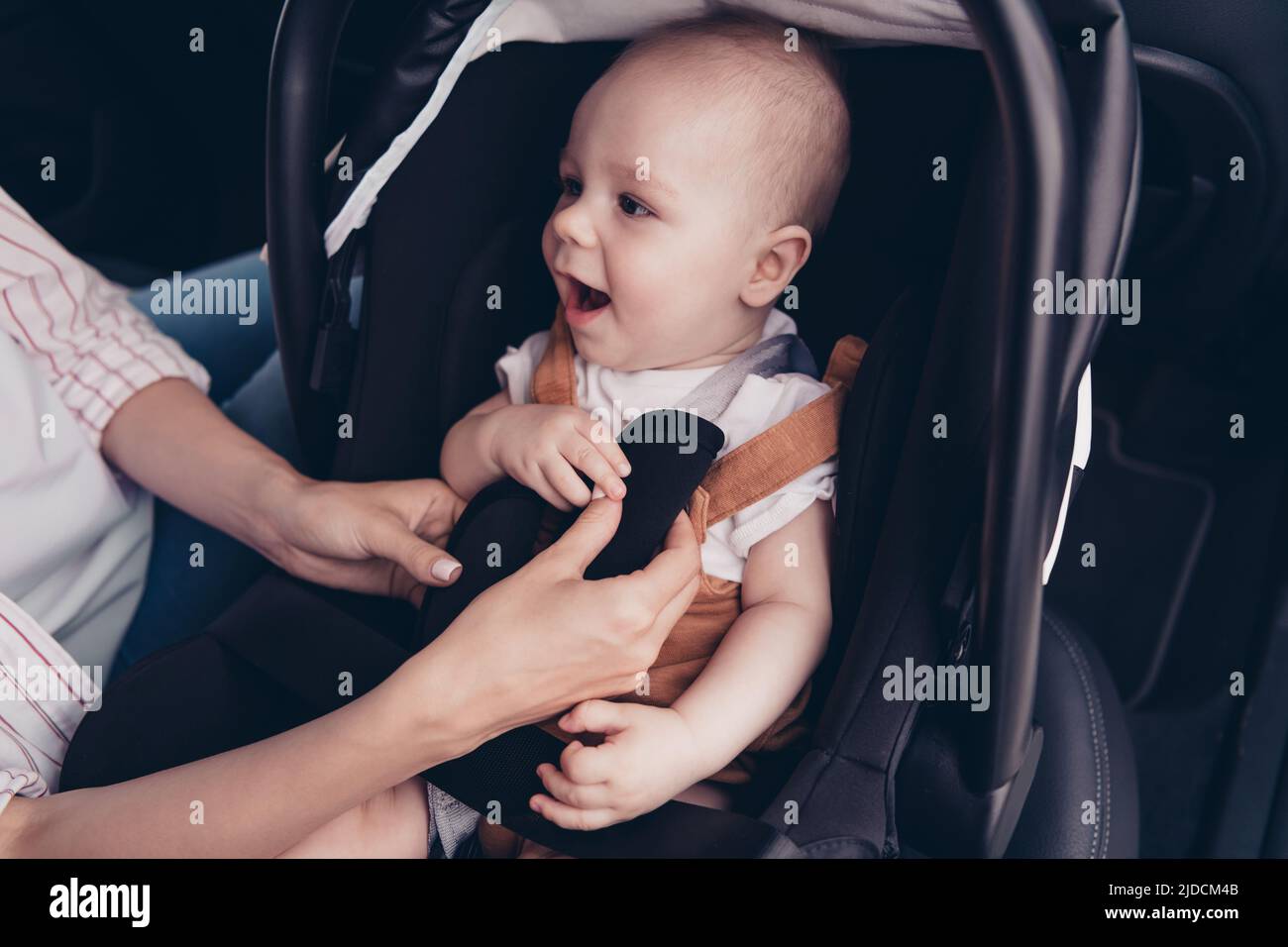 Cropped photo of mother hands put help toddle sitting safety baby chair ...
