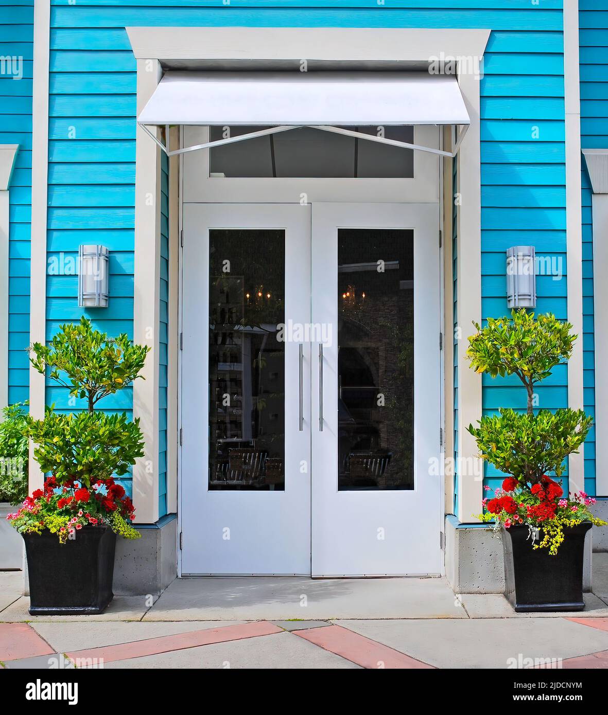 A shop entrance with decorative flowers at the doors Stock Photo - Alamy