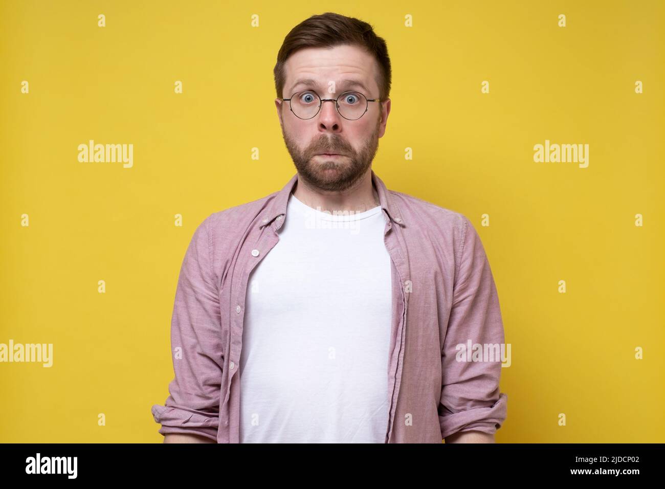 Man with glasses in a stupor stands motionless, he is frightened and ...