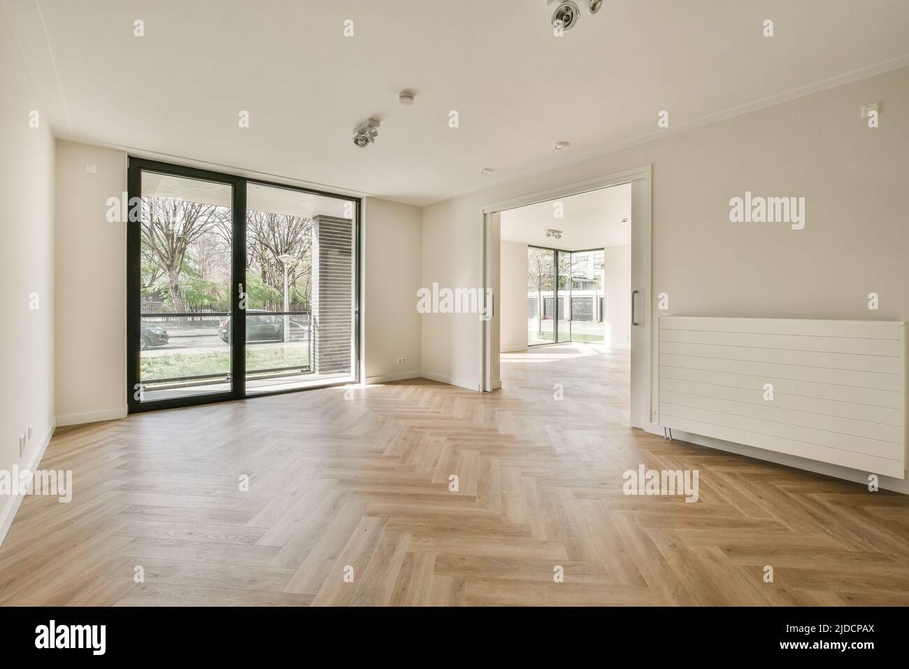 Spacious bright empty room with panoramic windows and parquet floor ...