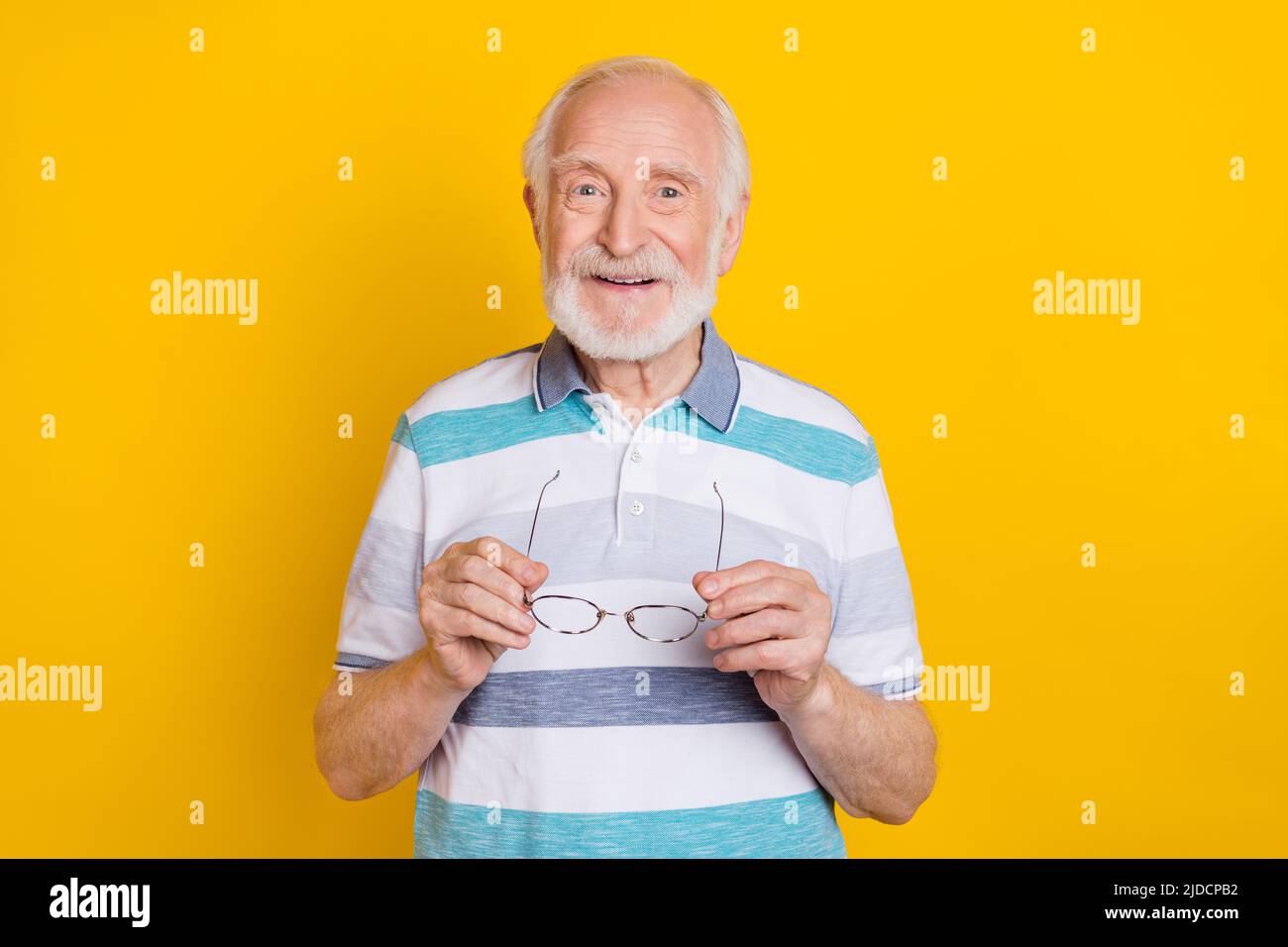 Portrait of attractive cheerful grey haired intellectual man holding in ...