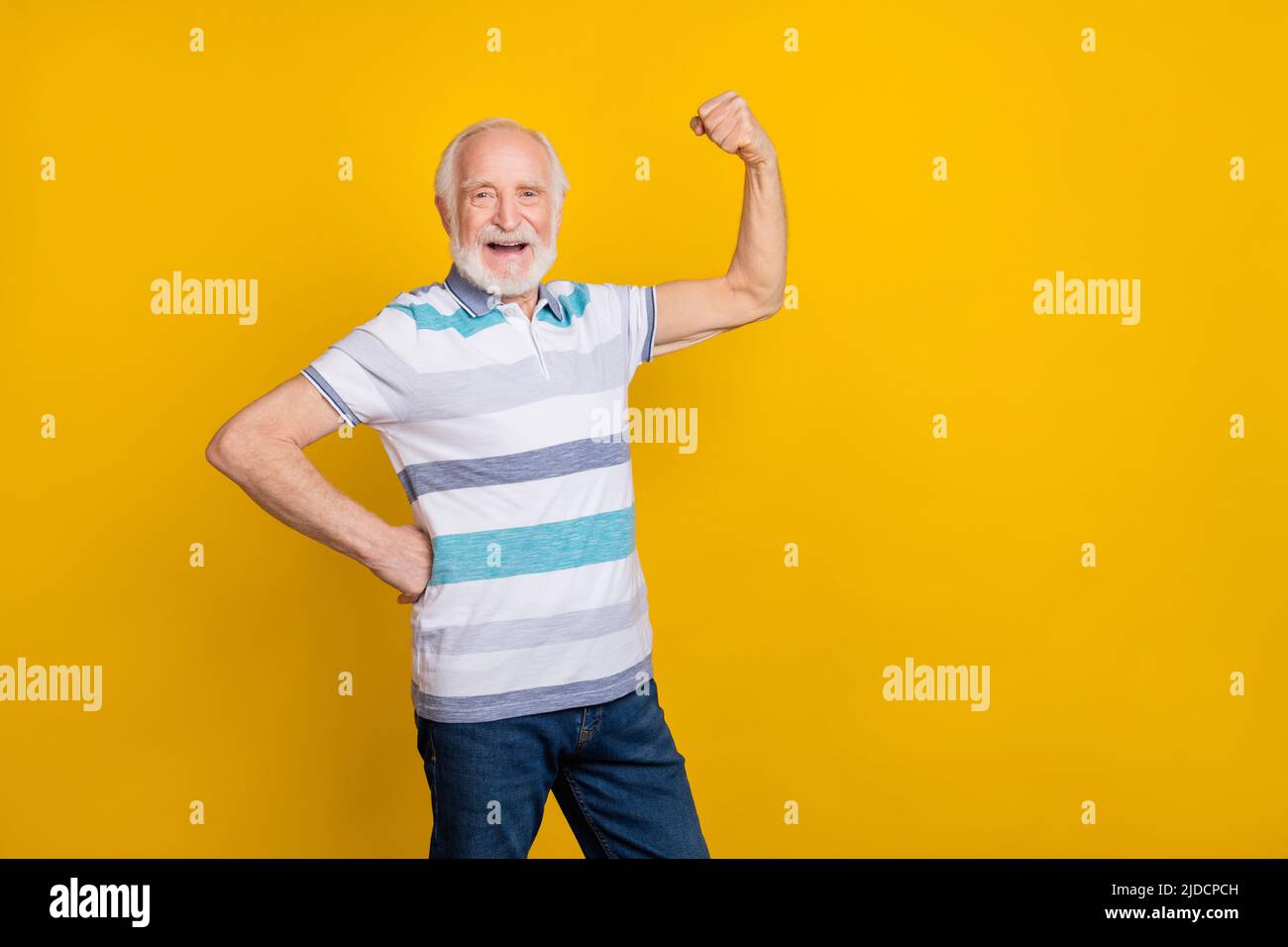 Portrait of attractive cheerful grey haired man demonstrating strong ...