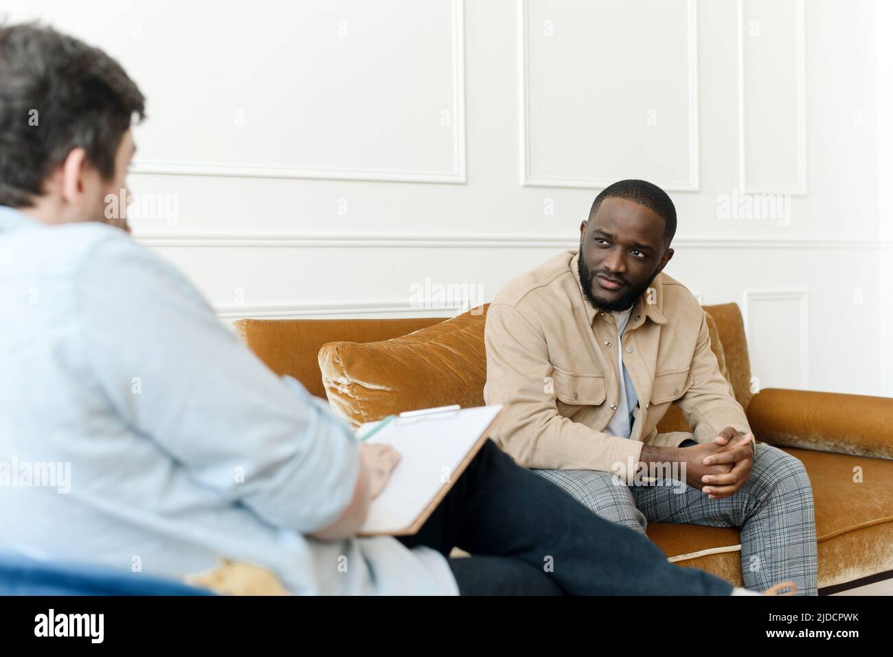 An irritated African American emotionally talks about problems to a ...