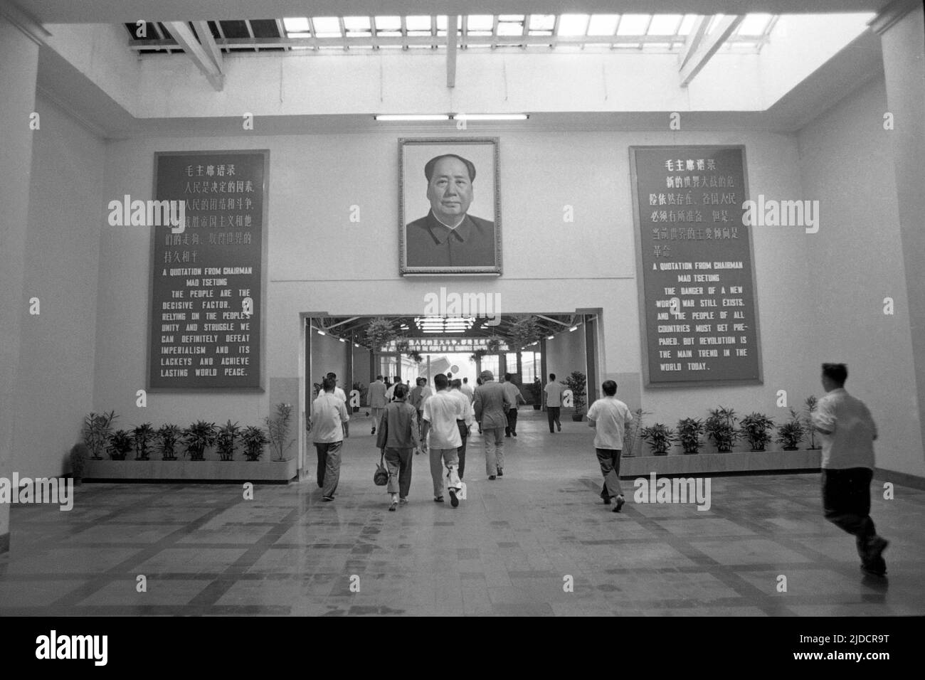 Chinese passers-by walk through a corridor, above the passageway a ...