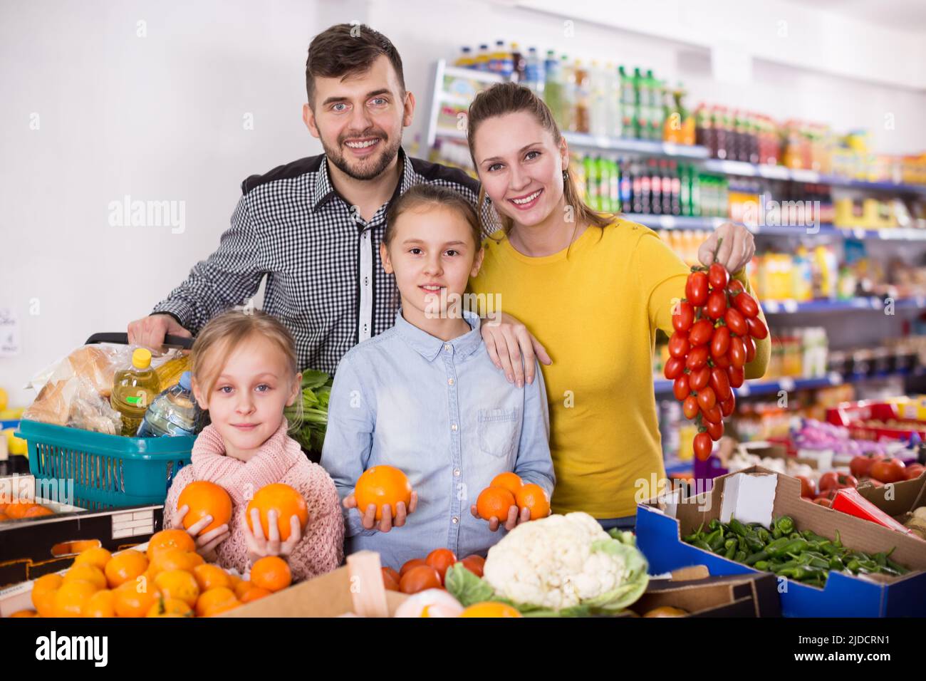 Family shopping together in greengrocery store choosing oranges Stock ...