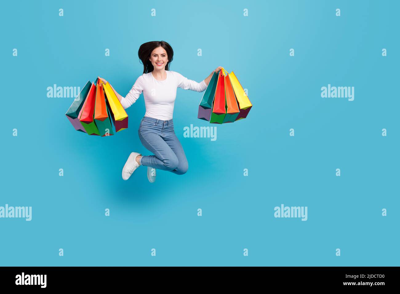 Photo of cute charming lady dressed white shirt jumping high rising ...