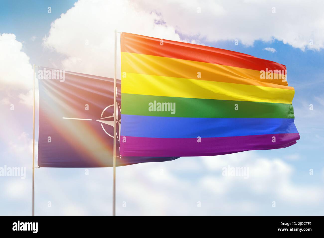 Sunny blue sky and flags of lgbt and nato Stock Photo - Alamy