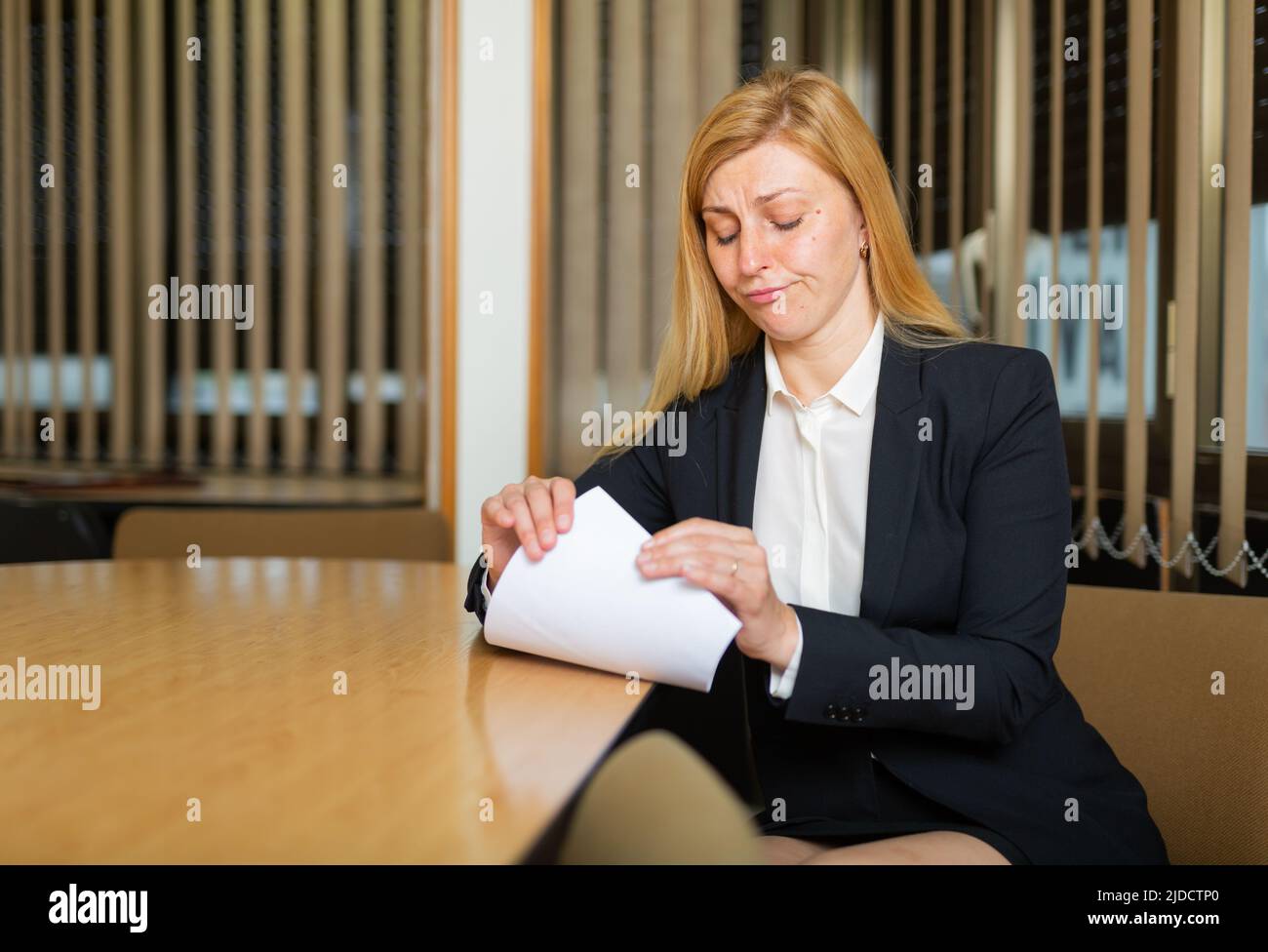 Upset female writing resignation letter Stock Photo - Alamy