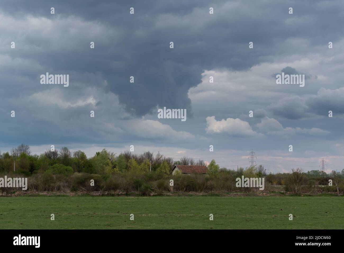 Funnel cloud above house in countryside, storm cloud in rural area ...