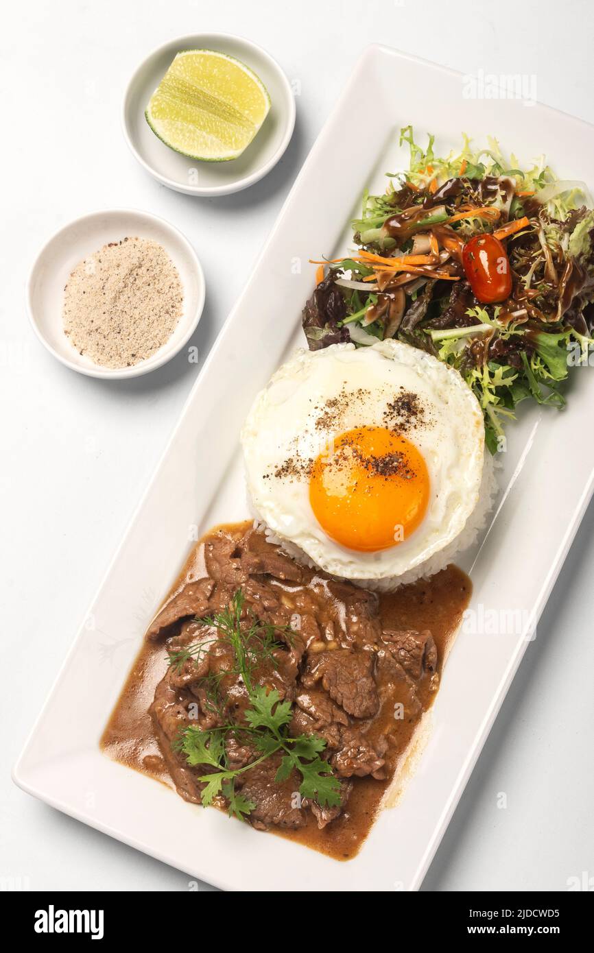 Traditional cambodian Lok Lak stir fried beef with rice meal on white ...
