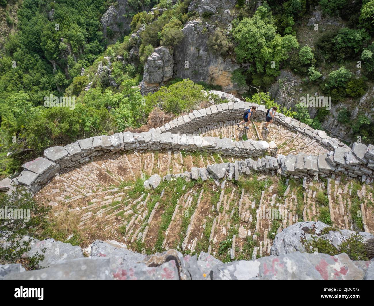 Two walkers climbing the Vradeto staircase or skala - an ancient ...