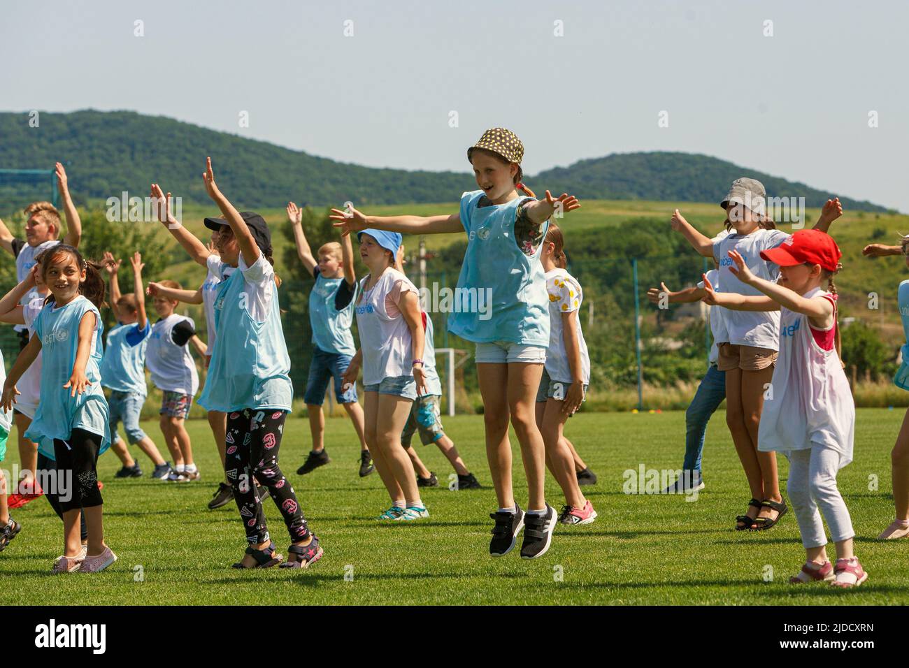 SEREDNIE, UKRAINE - JUNE 19, 2022 - Children do warm-up exercises as ...