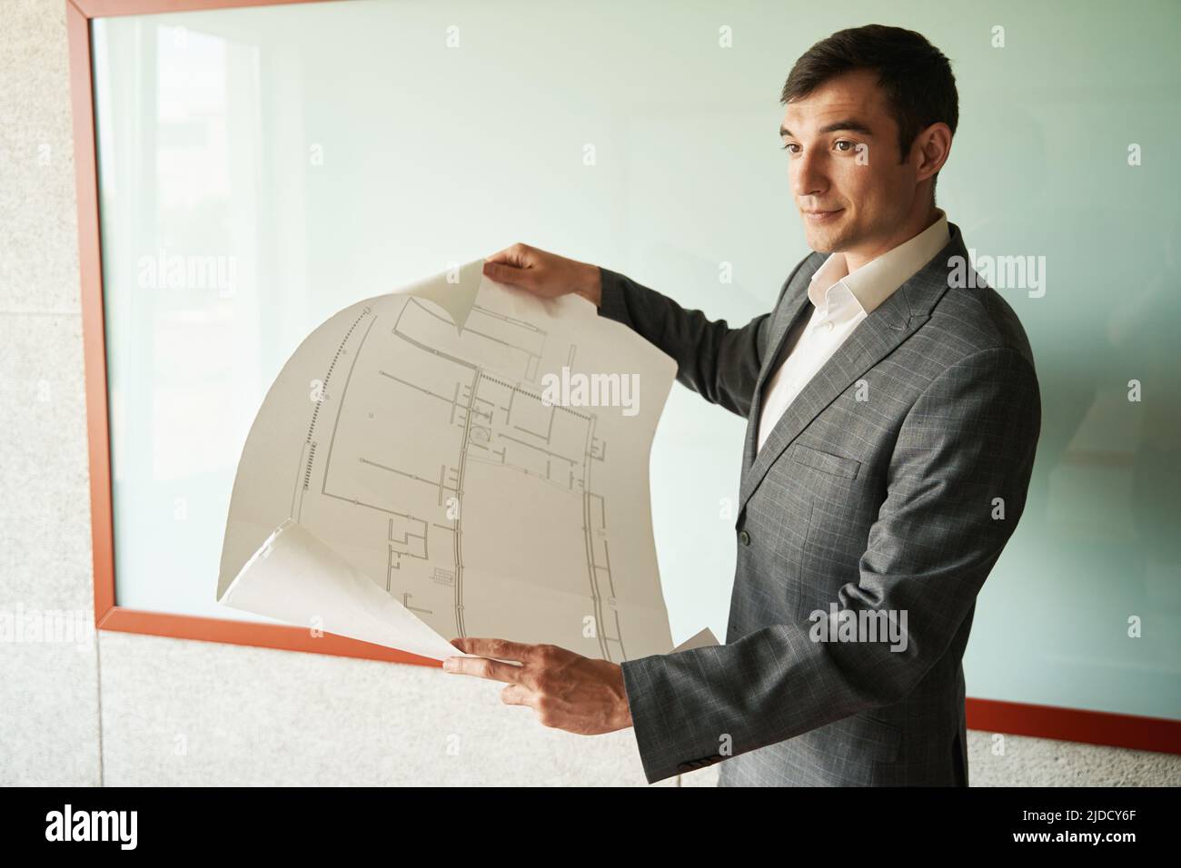 Architect spreading out drawings in his hands Stock Photo - Alamy