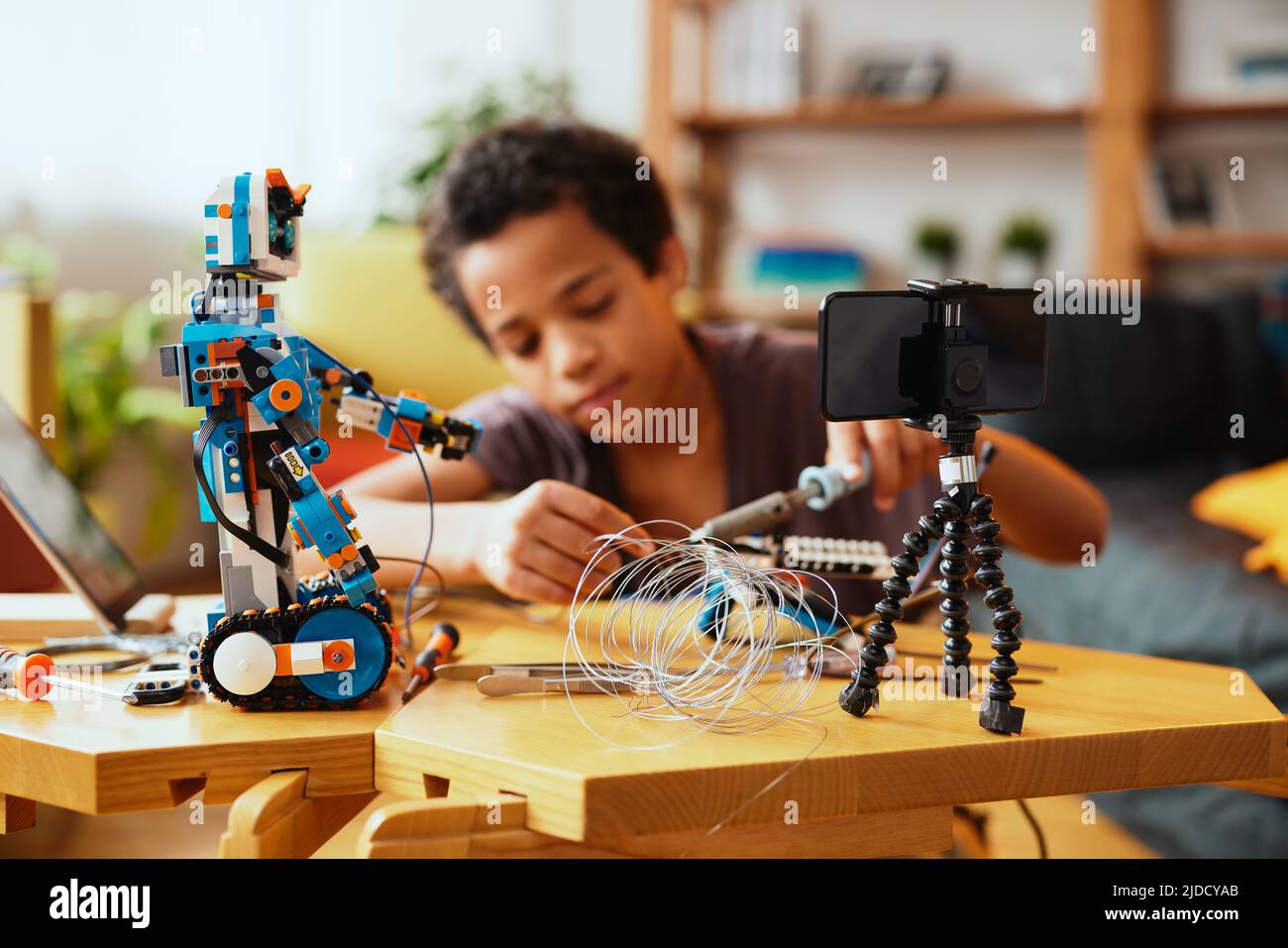 An educated little boy recording himself for a vlog and making a robot ...