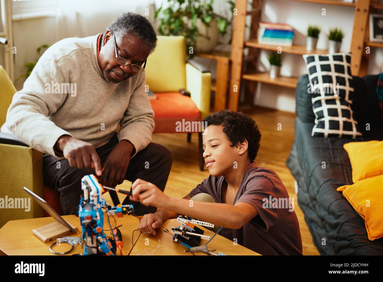A grandad and grandson making a robot together at home. Education in ...