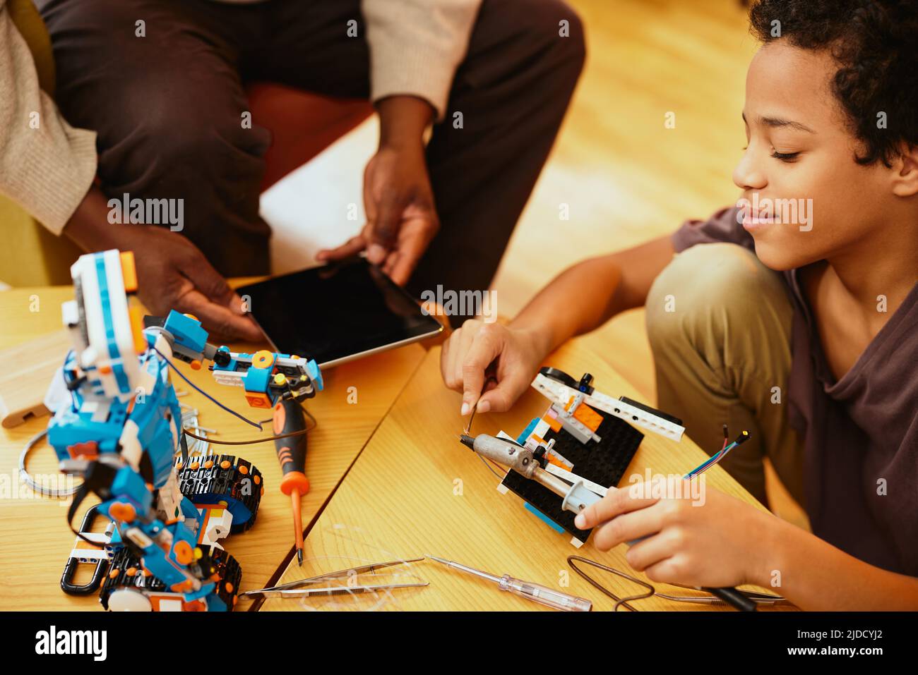 A grandad and grandson making a robot together at home. Education in ...