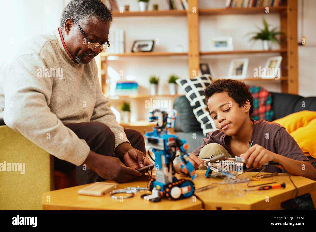 A grandad and grandson making a robot together at home. Education in ...