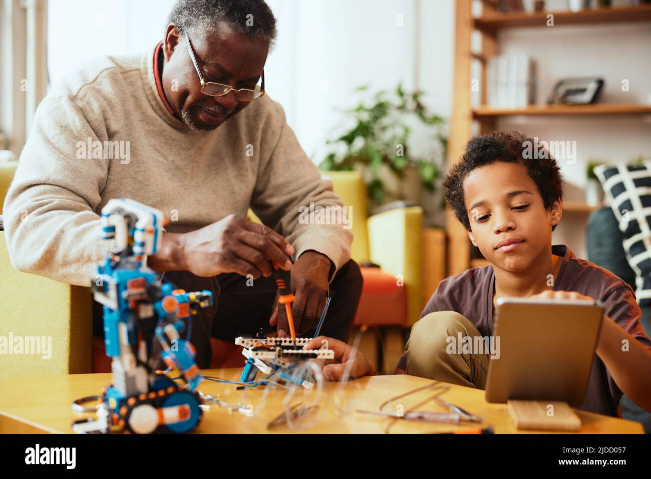 A grandad and grandson making a robot together at home. Education in ...