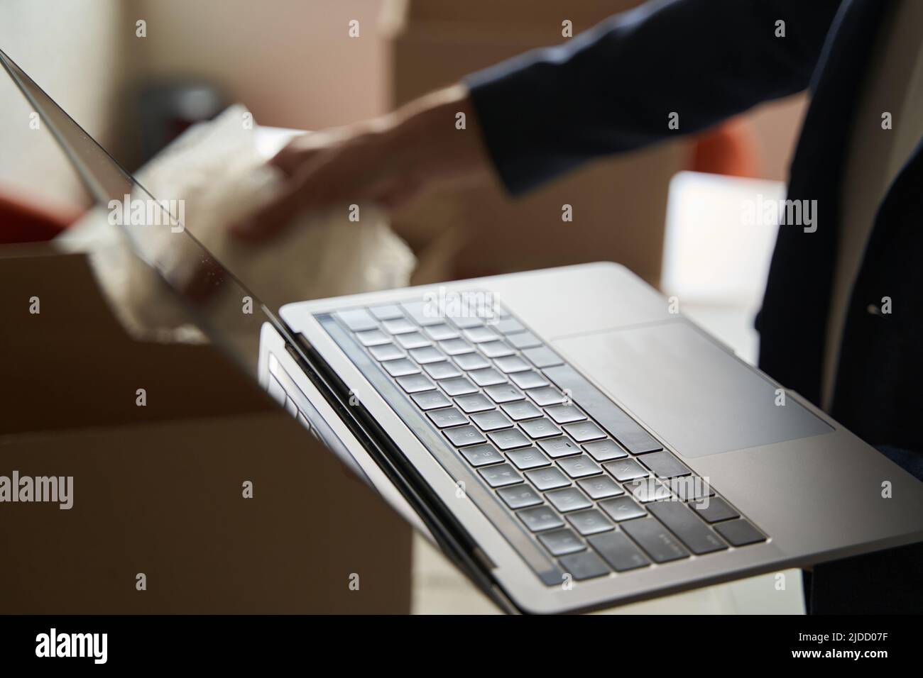 Laptop on hand of office clerk during delivery unpacking Stock Photo ...