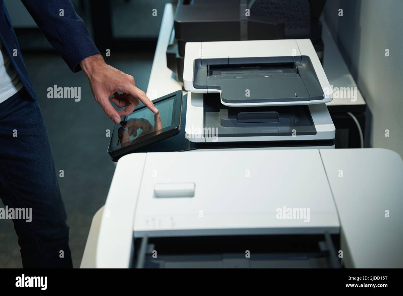 Person in office using printer and pressing on its screen Stock Photo ...