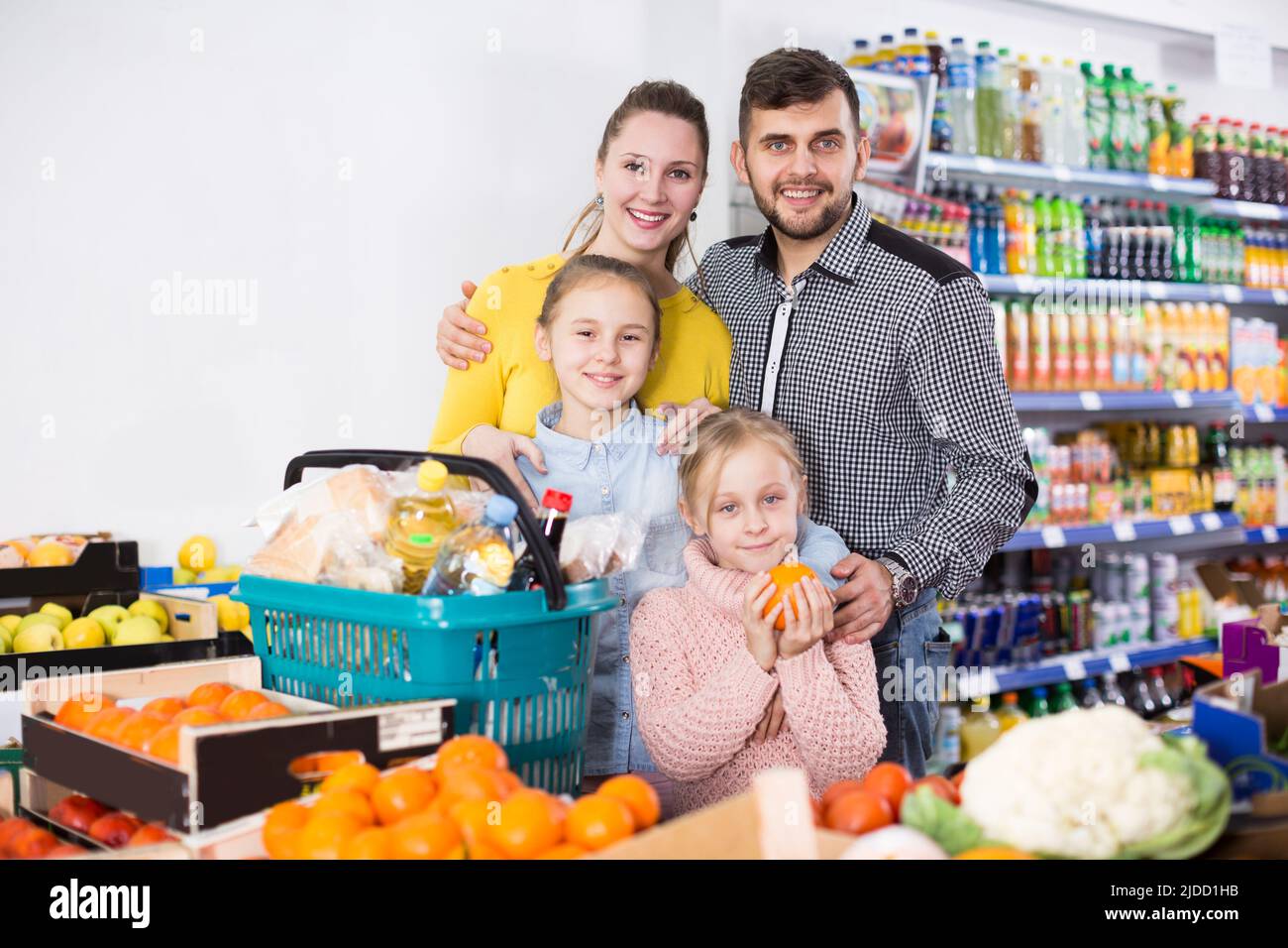 Glad parents with two girls choosing fruits Stock Photo - Alamy