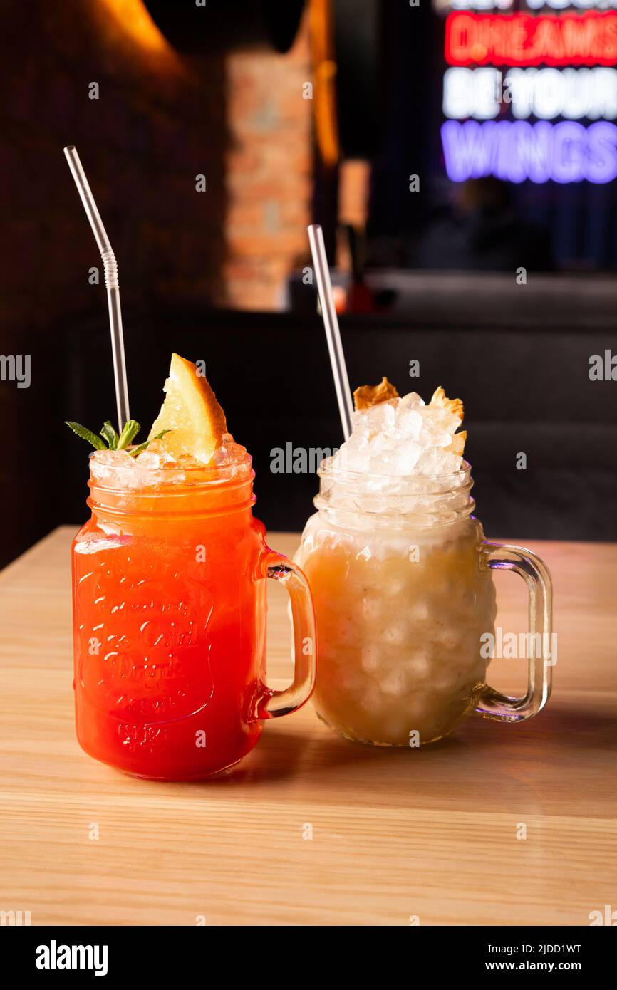 Red Strawberry lemonade with soda, ice, cocktail tube and orange slice ...