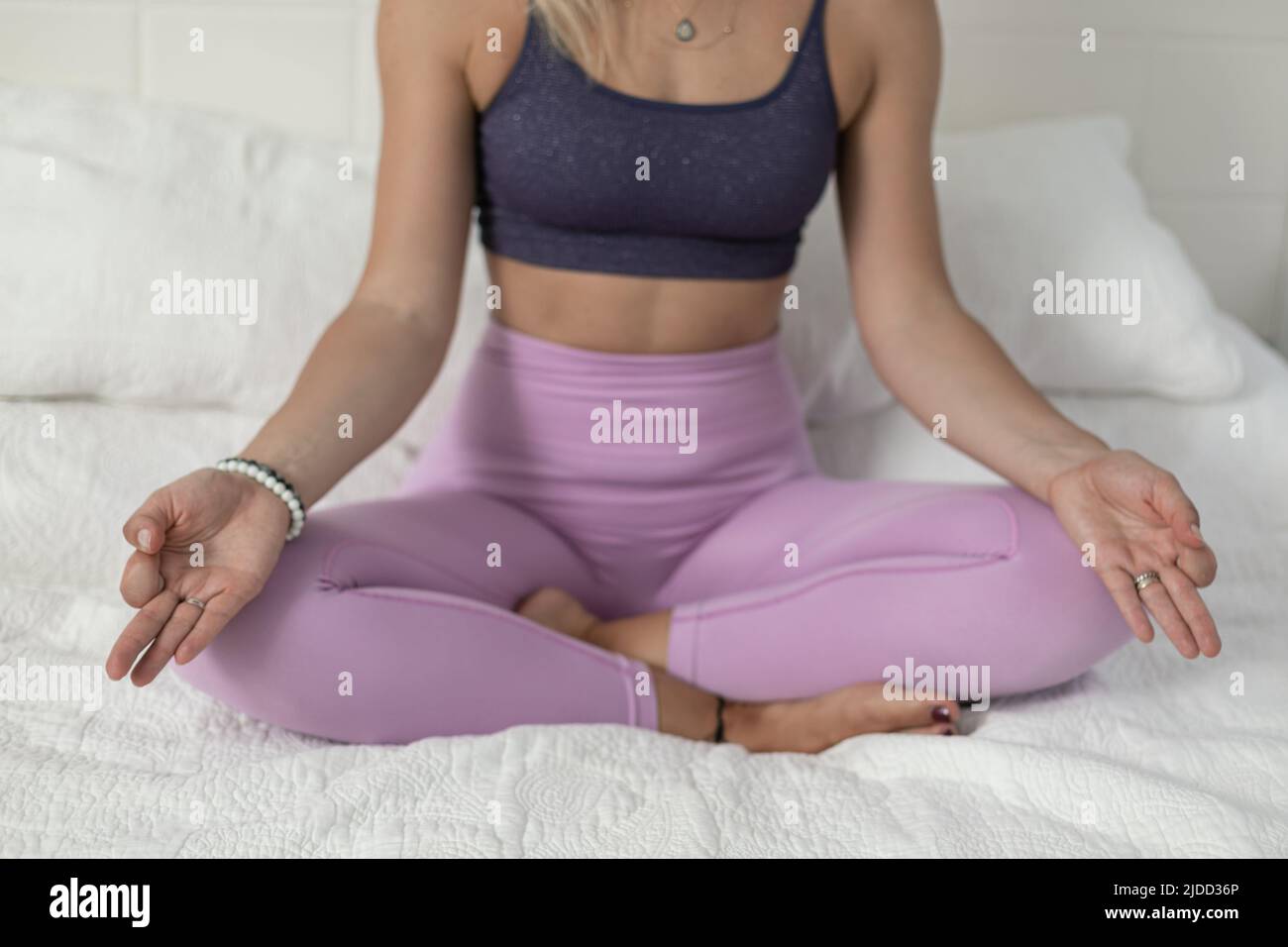 young woman practicing yoga poses, yoga teacher sitting in lotus ...