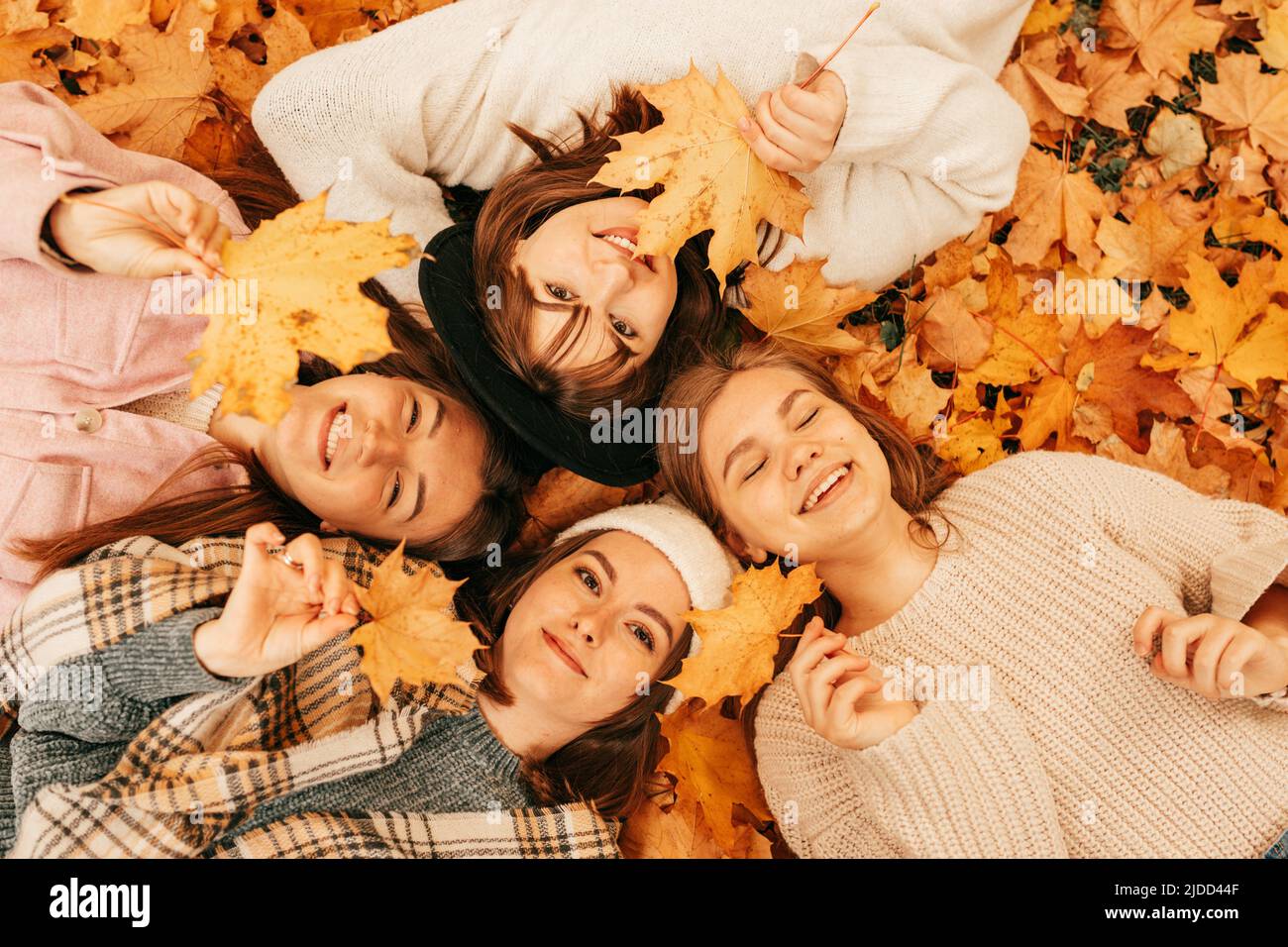 Happy people. Autumn portrait. Happy young women students playing with ...