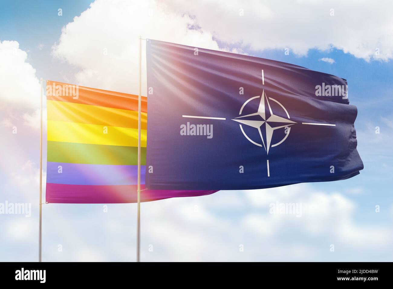 Sunny blue sky and flags of lgbt and nato Stock Photo - Alamy
