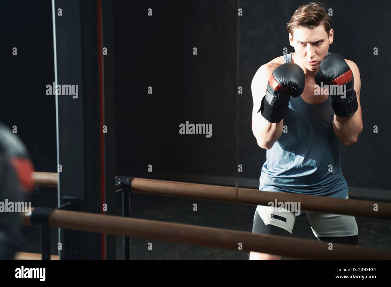 Concentrated sportsman working out before gym mirror Stock Photo - Alamy