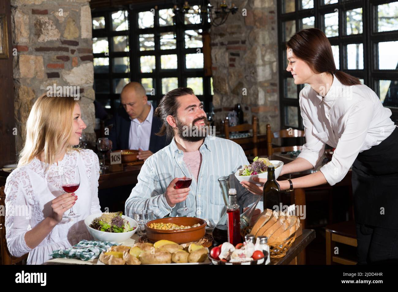 Waitress bringing dishes to guests Stock Photo - Alamy