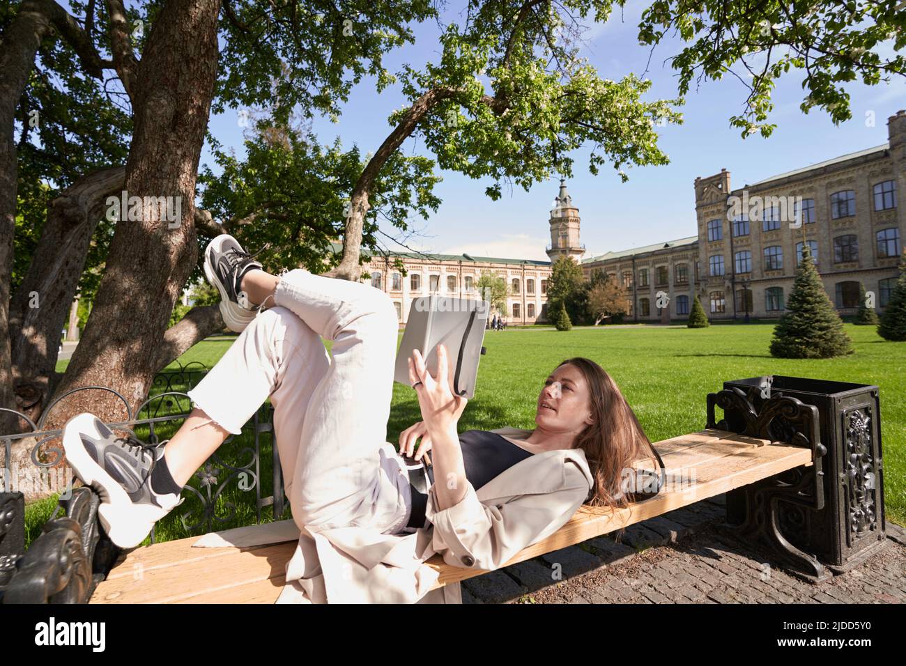 Lady reads notes in a notebook on a park bench Stock Photo - Alamy