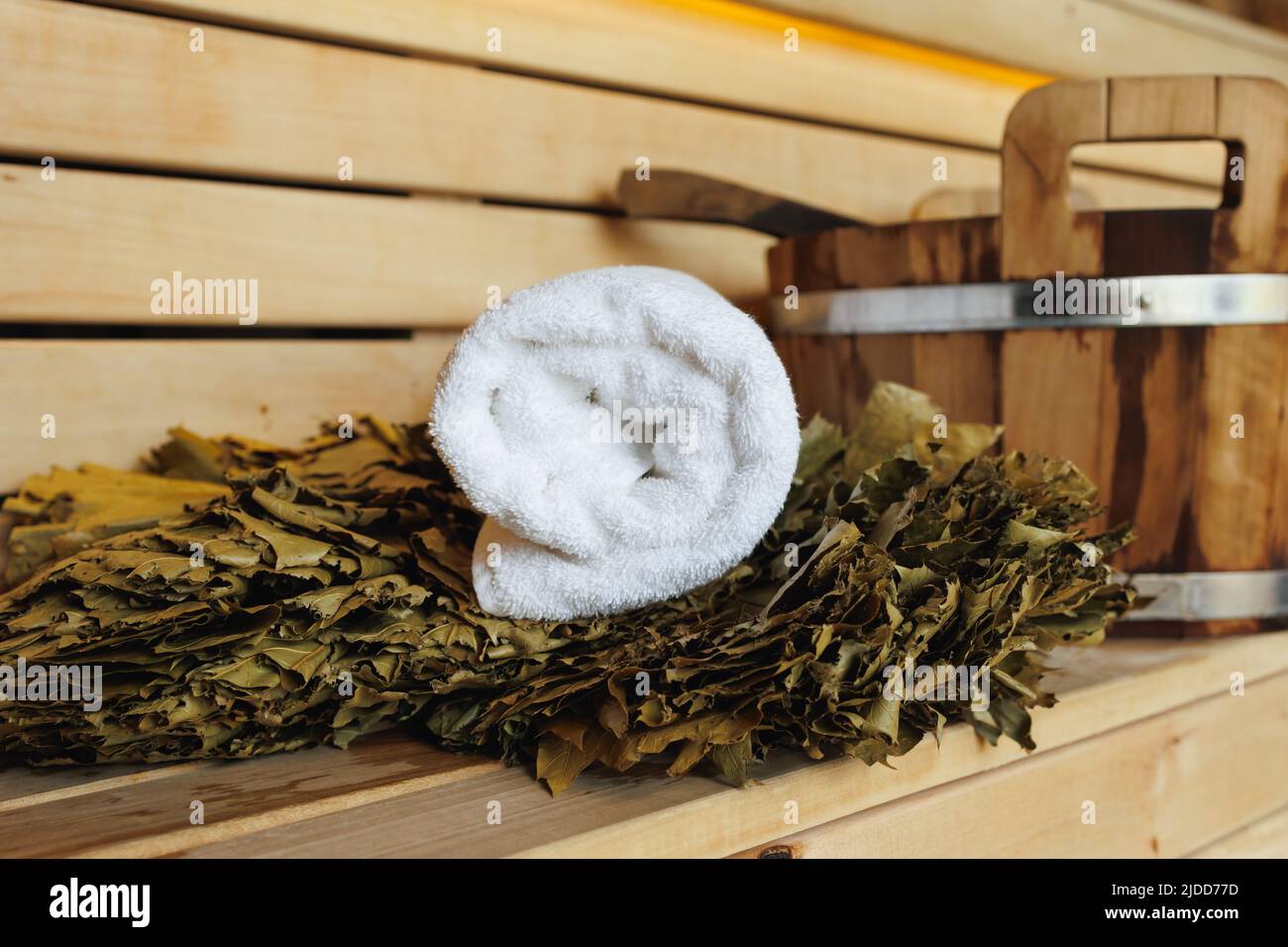 Traditional sauna detail and accessories. White towel, broom and wooden ...
